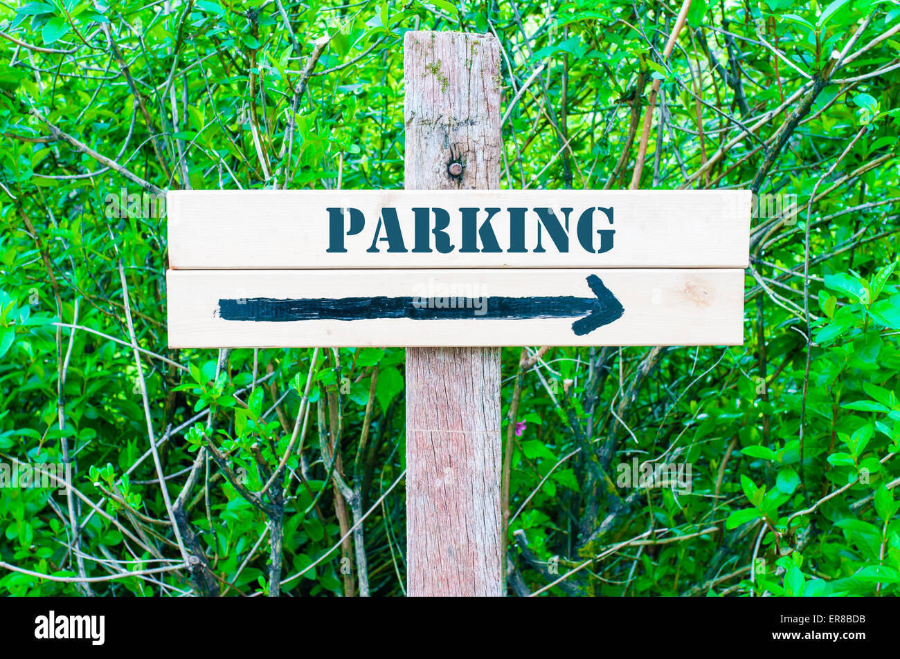 PARKING written on Directional wooden sign with arrow pointing to the ...