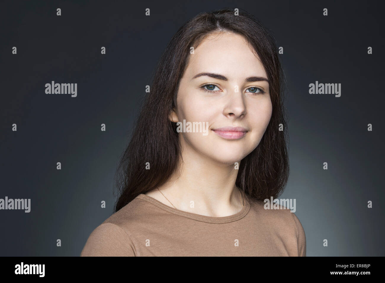 Portrait of beautiful young woman over gray background Stock Photo - Alamy