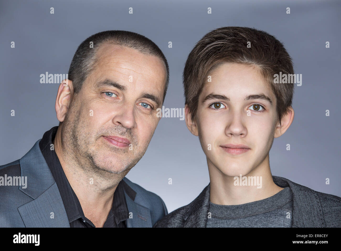 Portrait of confident father with son over gray background Stock Photo ...