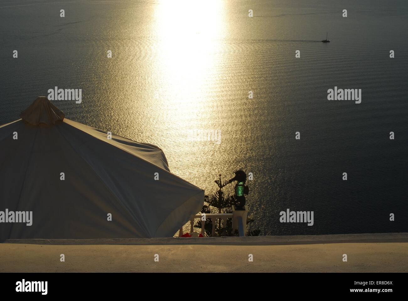 Santorini, Greece, sunset reflection off a calm sea in the caldera of ...