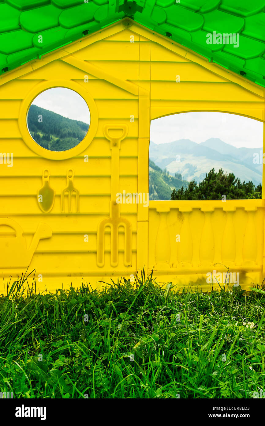 Exterior of yellow house with reflections of mountains on its windows ...
