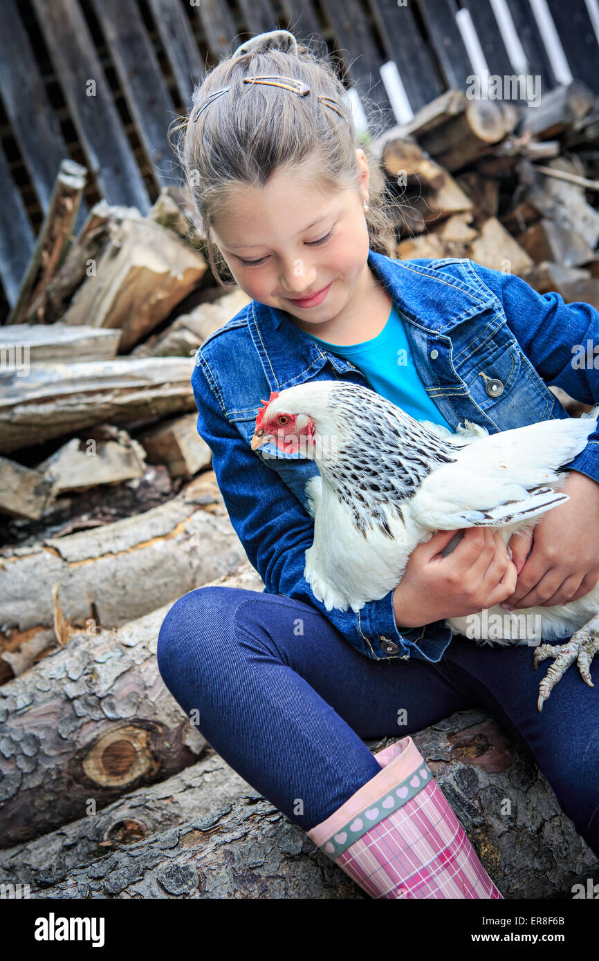 little girl with a hen in front of the farm Stock Photo - Alamy