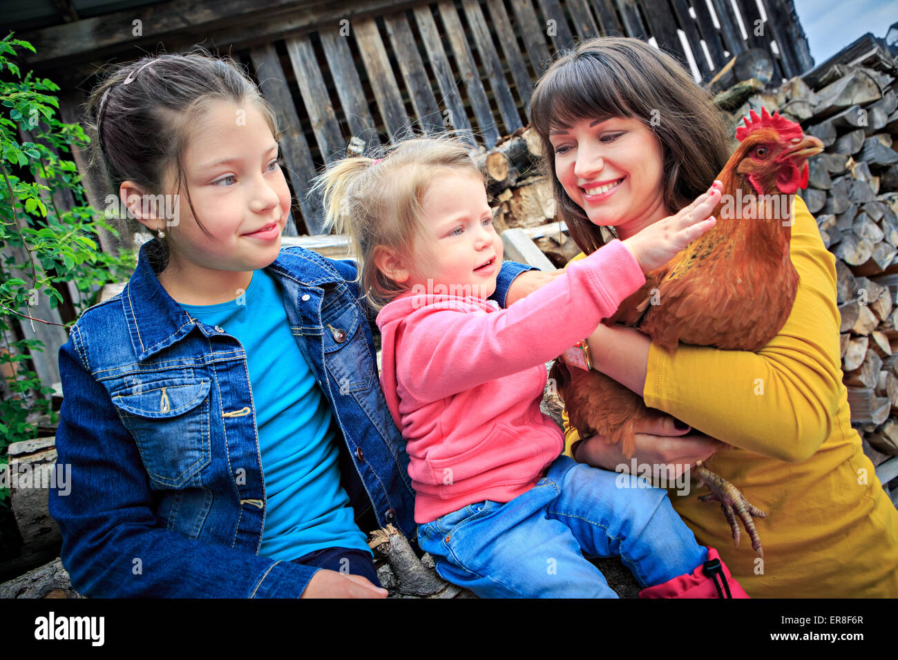 a farm family with a hen in front of the farm Stock Photo - Alamy