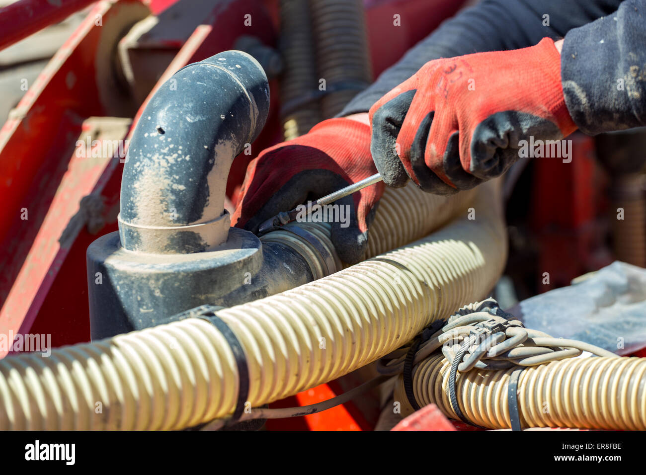 The worker repairing the machine on the field Stock Photo - Alamy