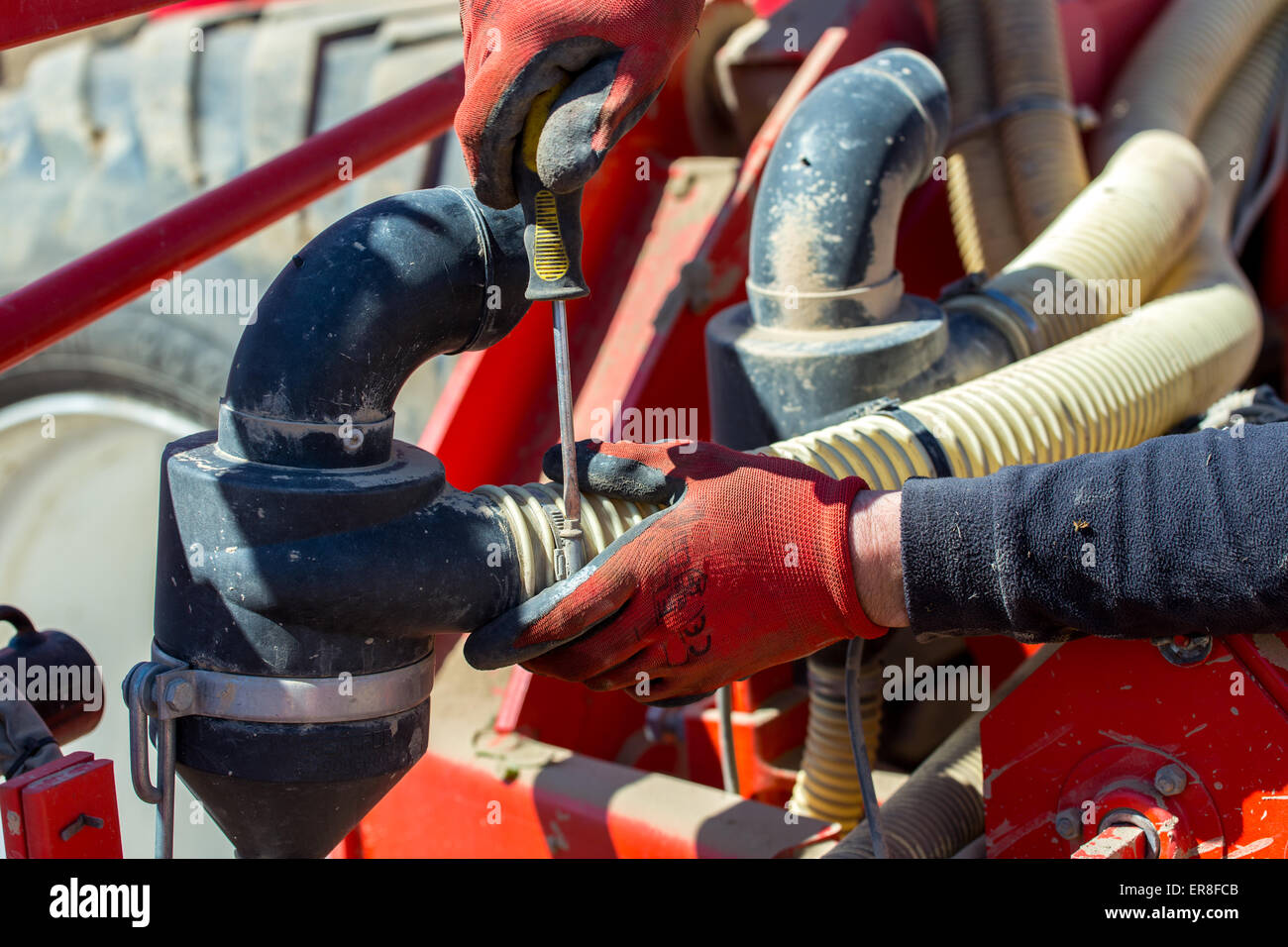 The worker repairing the machine on the field Stock Photo - Alamy