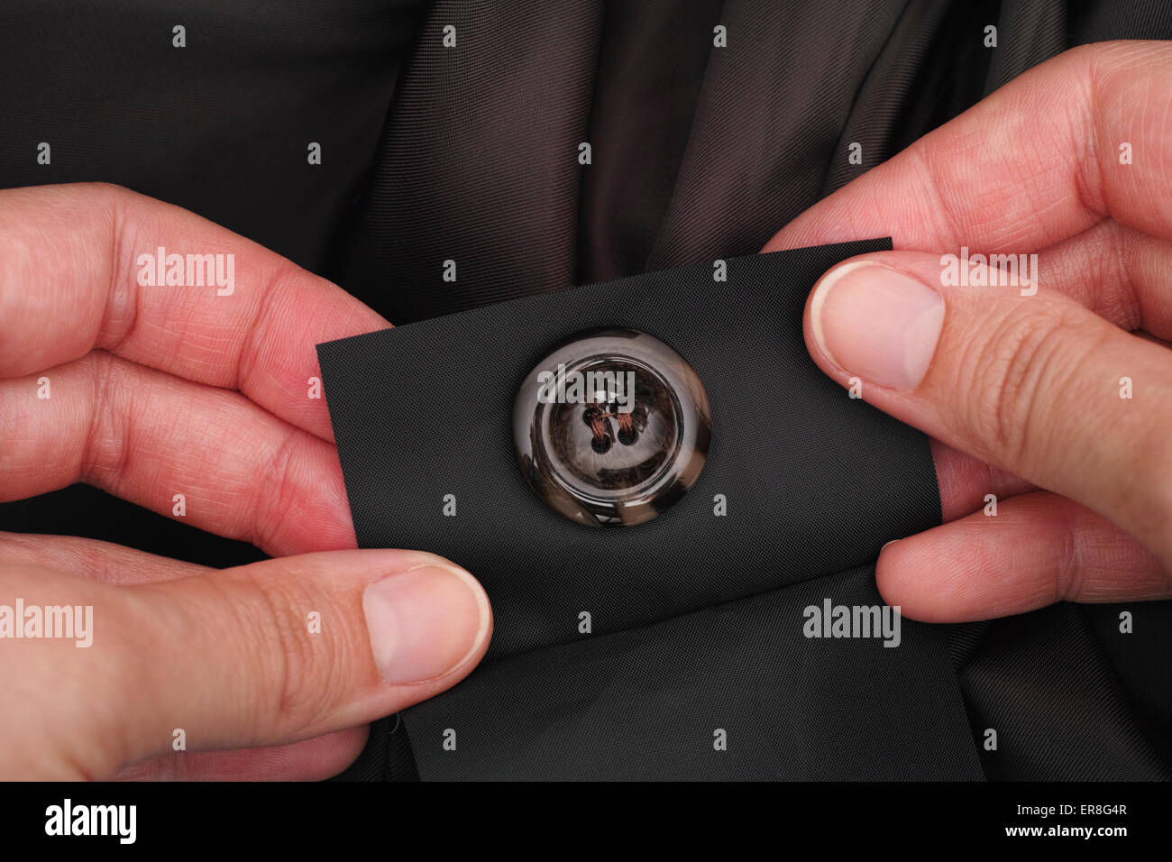 Woman's hands holding button on clothing Stock Photo - Alamy