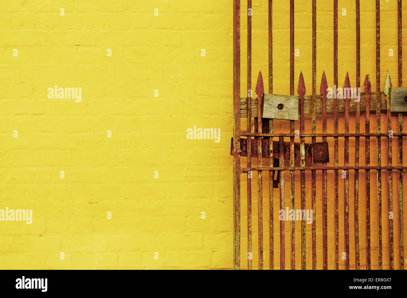 Rusty antique lock gate and bright yellow wall Stock Photo - Alamy