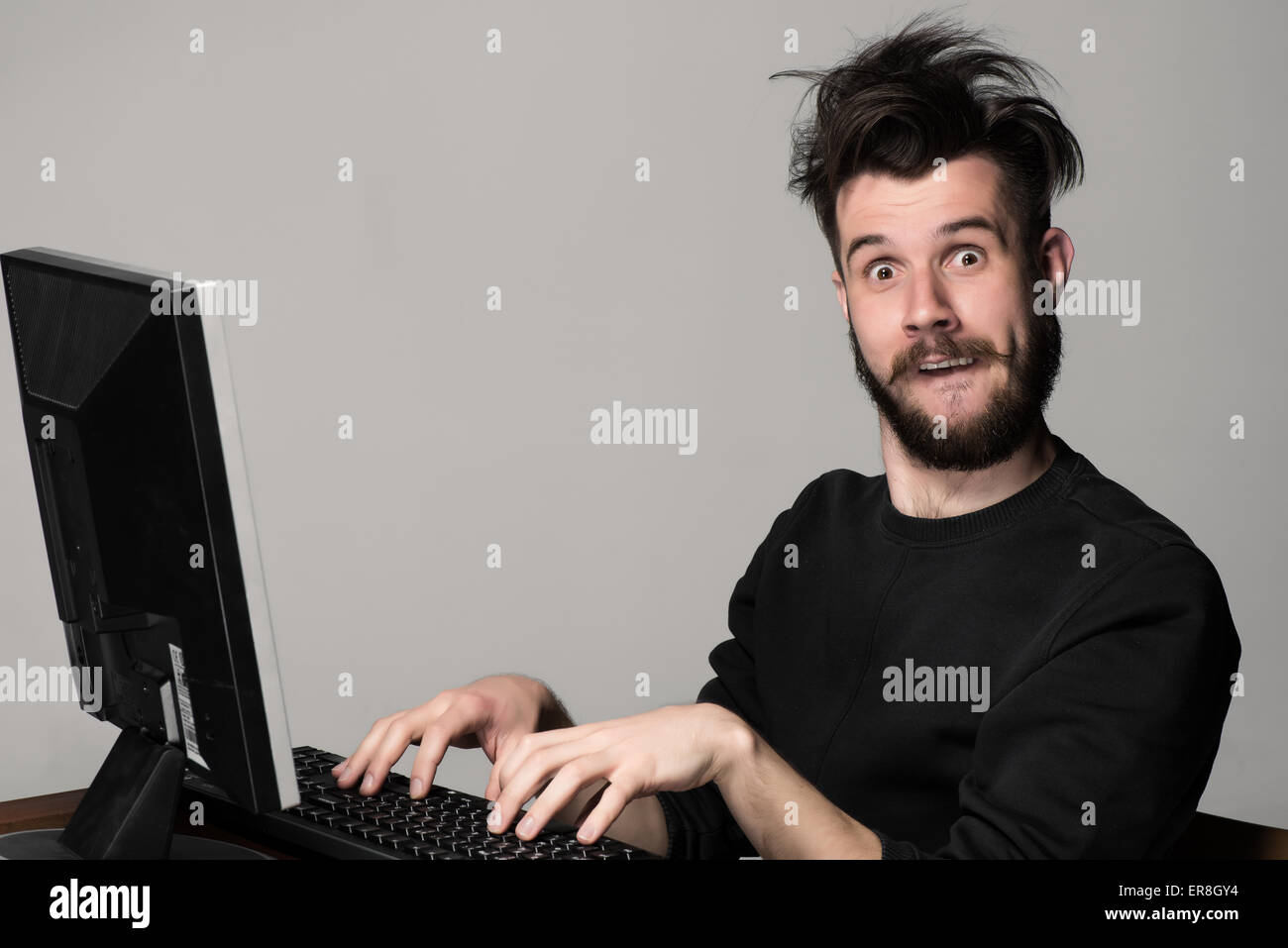 Funny and crazy man using a computer on gray background. man's hands on ...