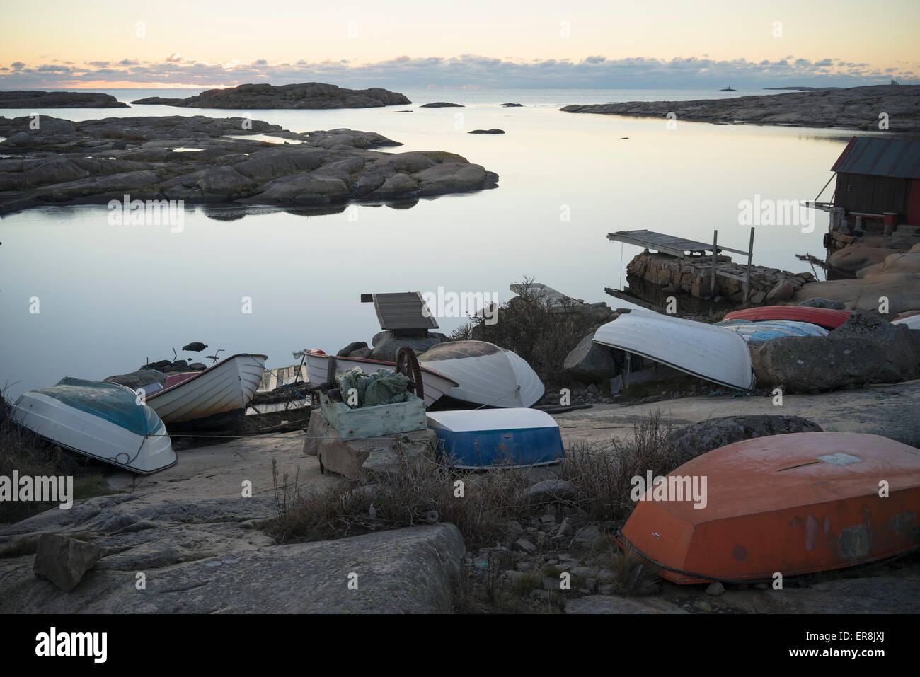 Upside down boats on rocks by lake Stock Photo - Alamy