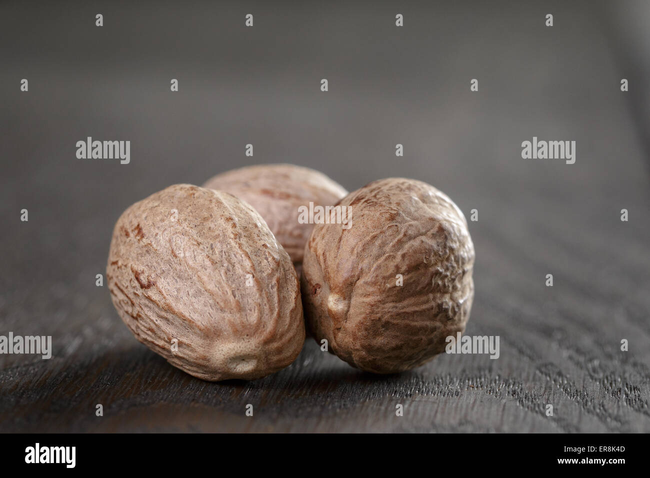 whole nutmegs on oak table, rustic Stock Photo - Alamy