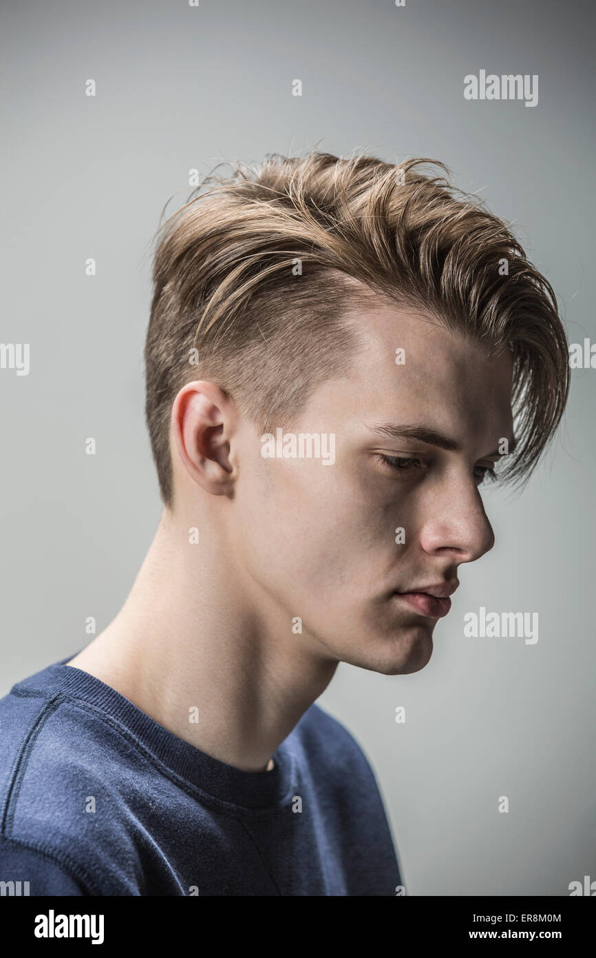 Sad young man against gray background Stock Photo - Alamy