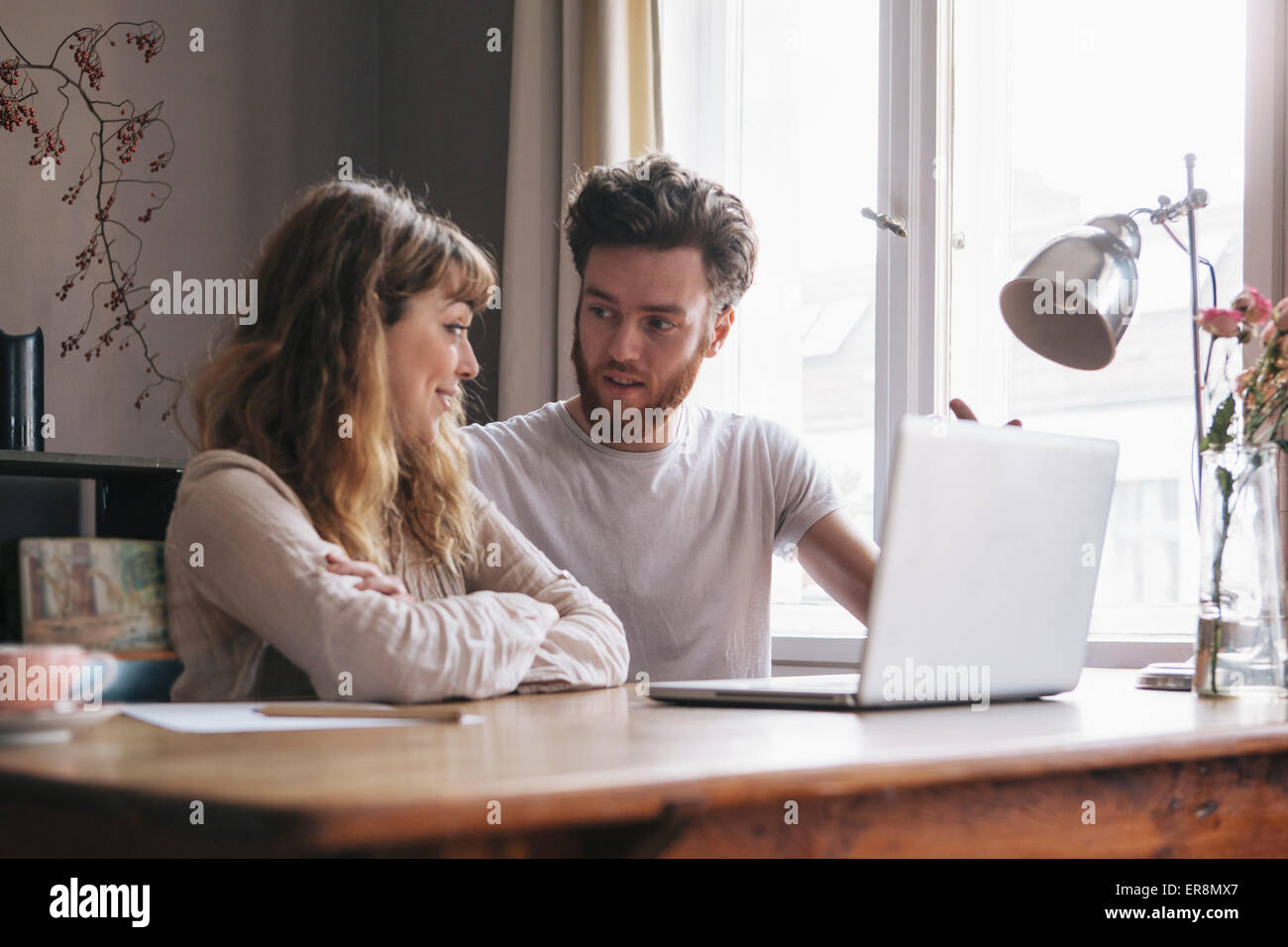 Young couple having discussion with laptop on table at home Stock Photo ...
