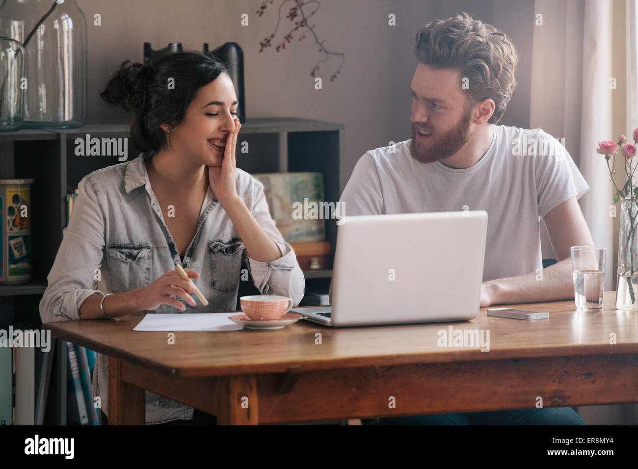 Young couple having discussion with laptop on table at home Stock Photo ...