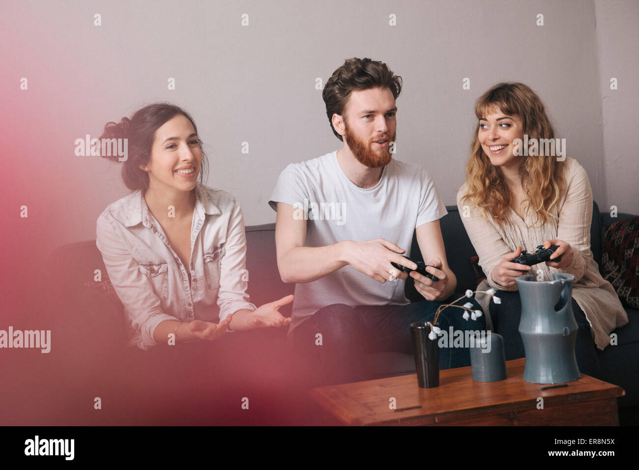 Excited young friends playing video games at home Stock Photo - Alamy