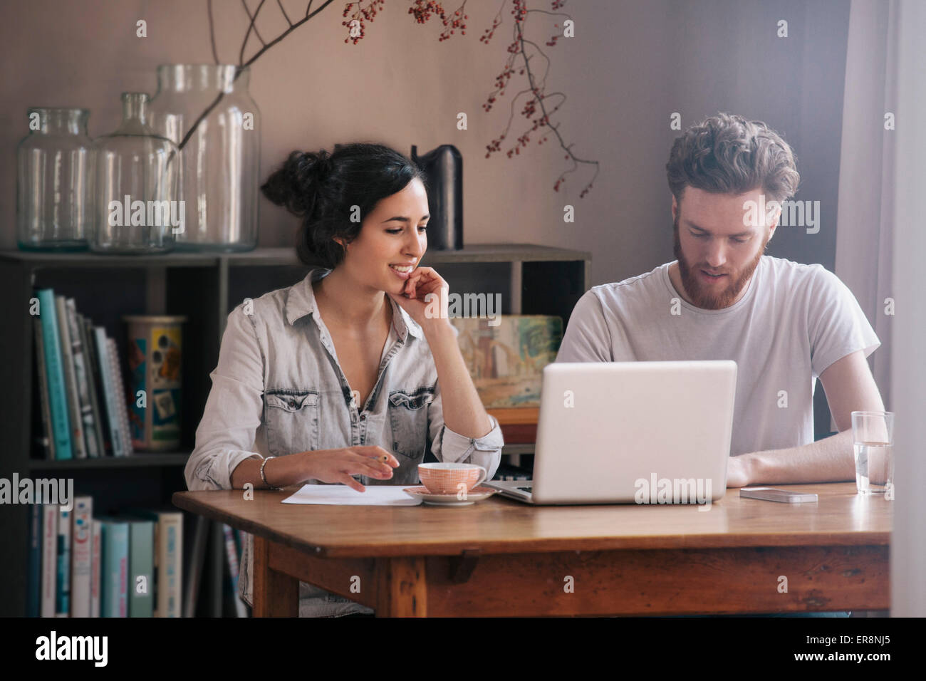 Young couple having discussion with laptop on table at home Stock Photo ...