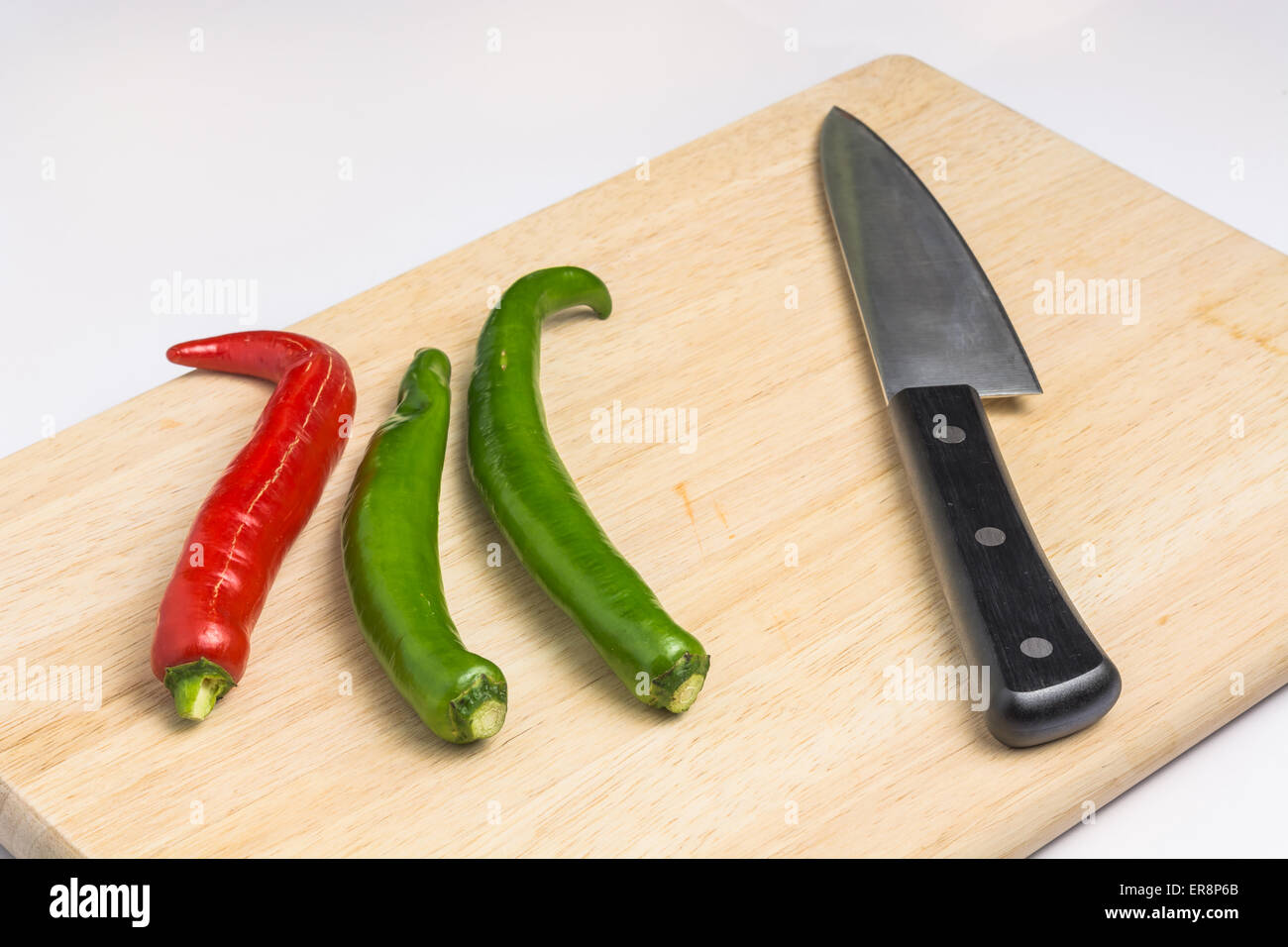 Fresh peppers on the chopping block preparation cooking Stock Photo - Alamy