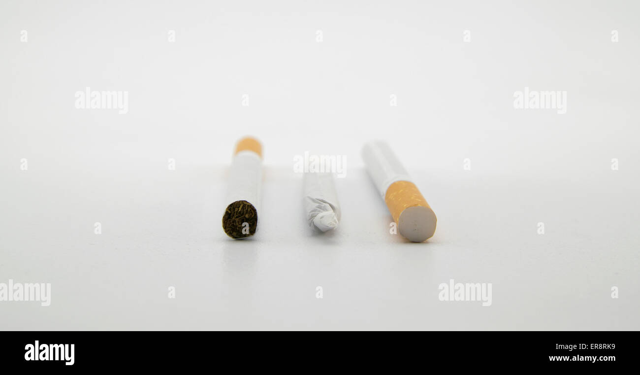 two cigarettes and a hand rolled cigarette Stock Photo - Alamy