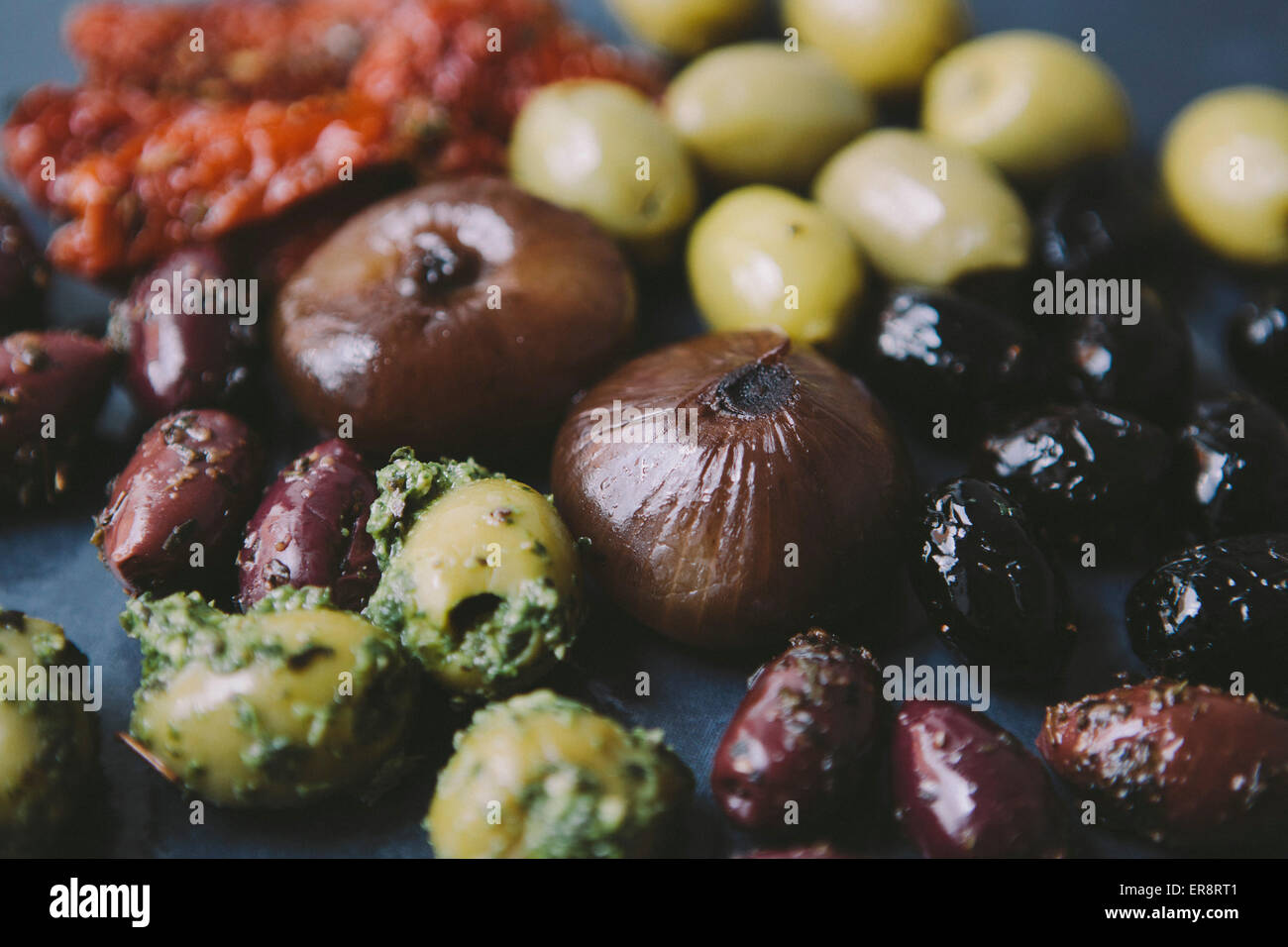 Various olives with onions on table Stock Photo - Alamy
