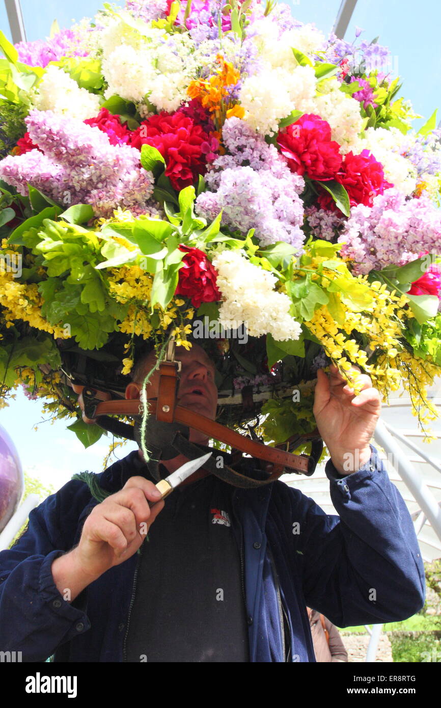 A garland maker puts the finishing touches to a floral headdress made ...
