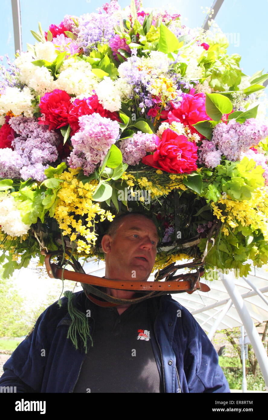 A garland maker puts the finishing touches to a floral headdress made ...