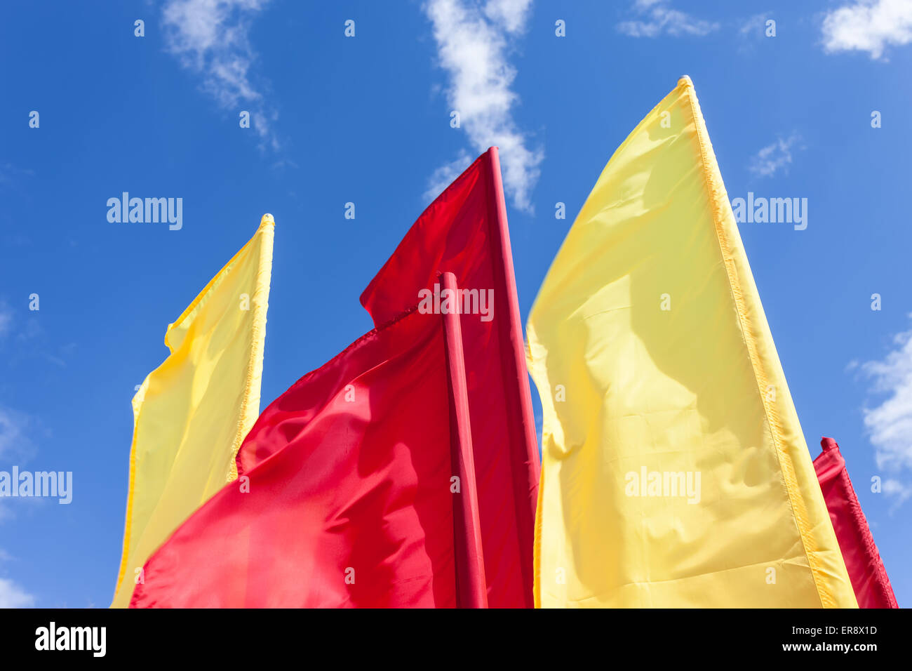 Red and yellow flags fluttering in the wind against blue sky Stock ...