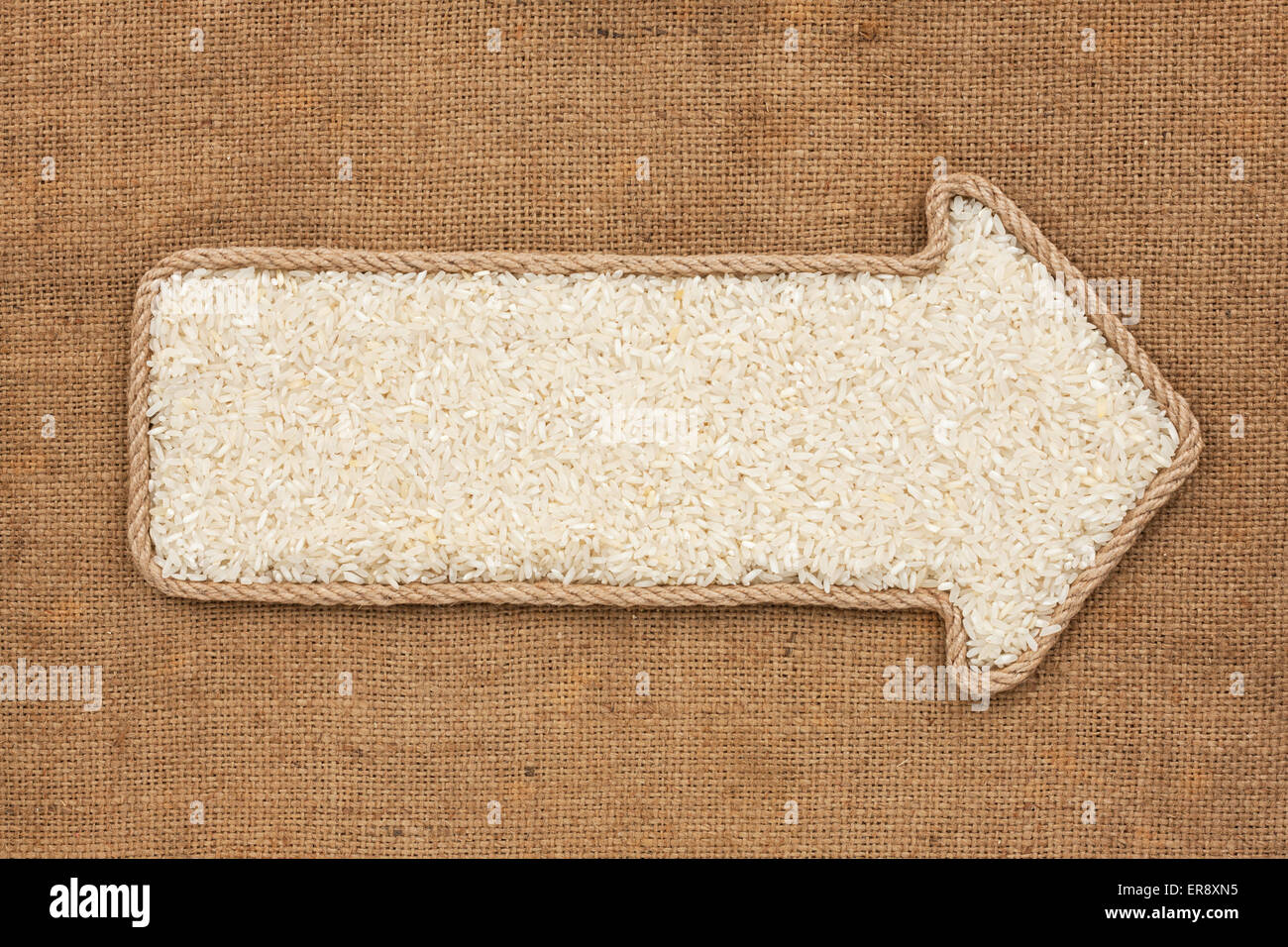 Pointer made from rope with grain rice lying on sackcloth, with space ...