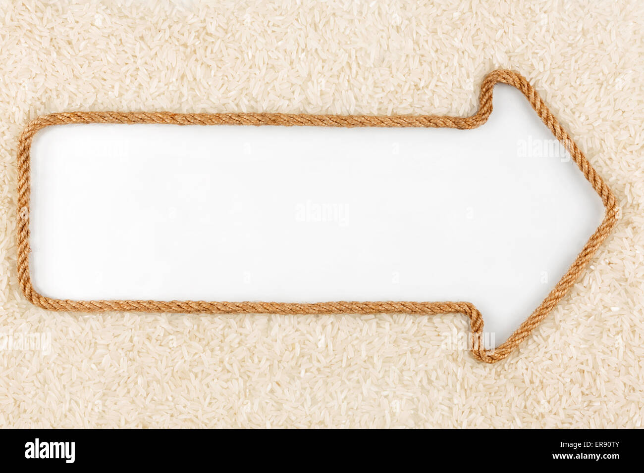 Arrow made of rope and rice with a white background, with place for ...