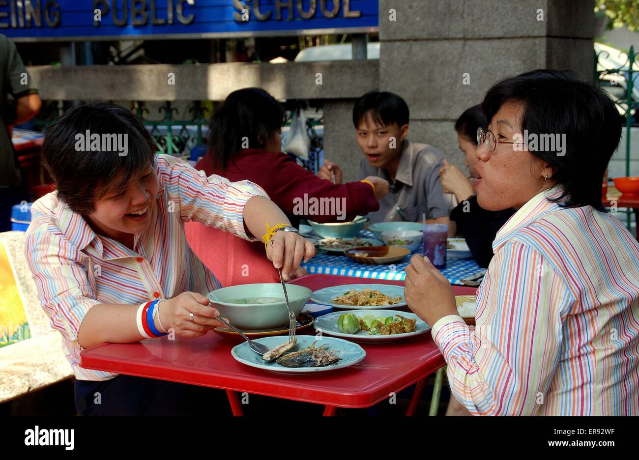 Bangkok, Thailand: Thais seated at metal tables eating lunch outdoors ...