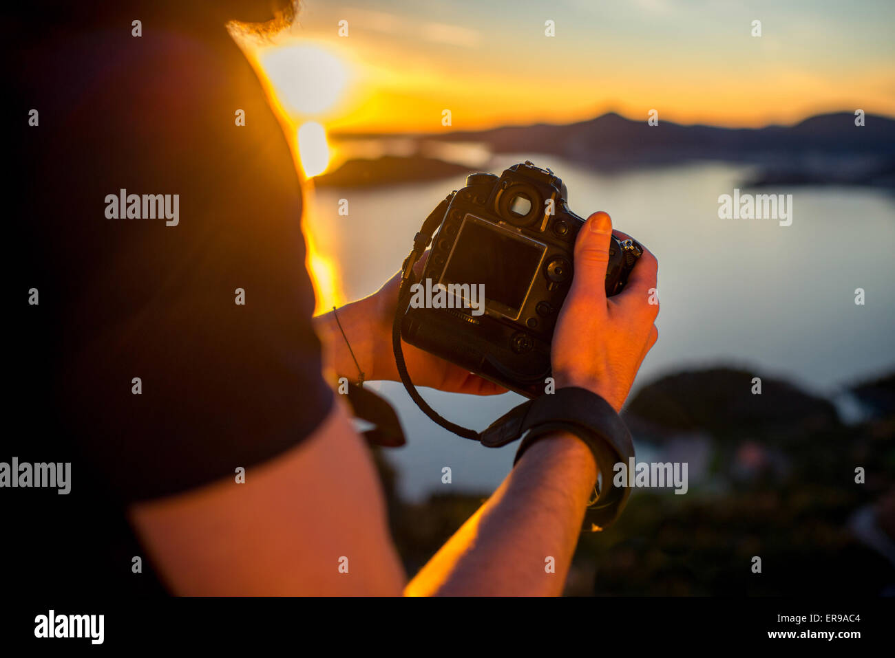 Man photographing sunset on the top of mountain Stock Photo - Alamy