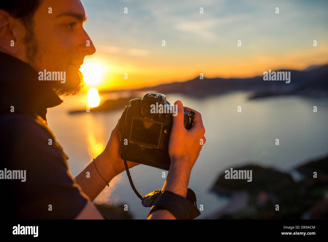 Man photographing sunset on the top of mountain Stock Photo - Alamy