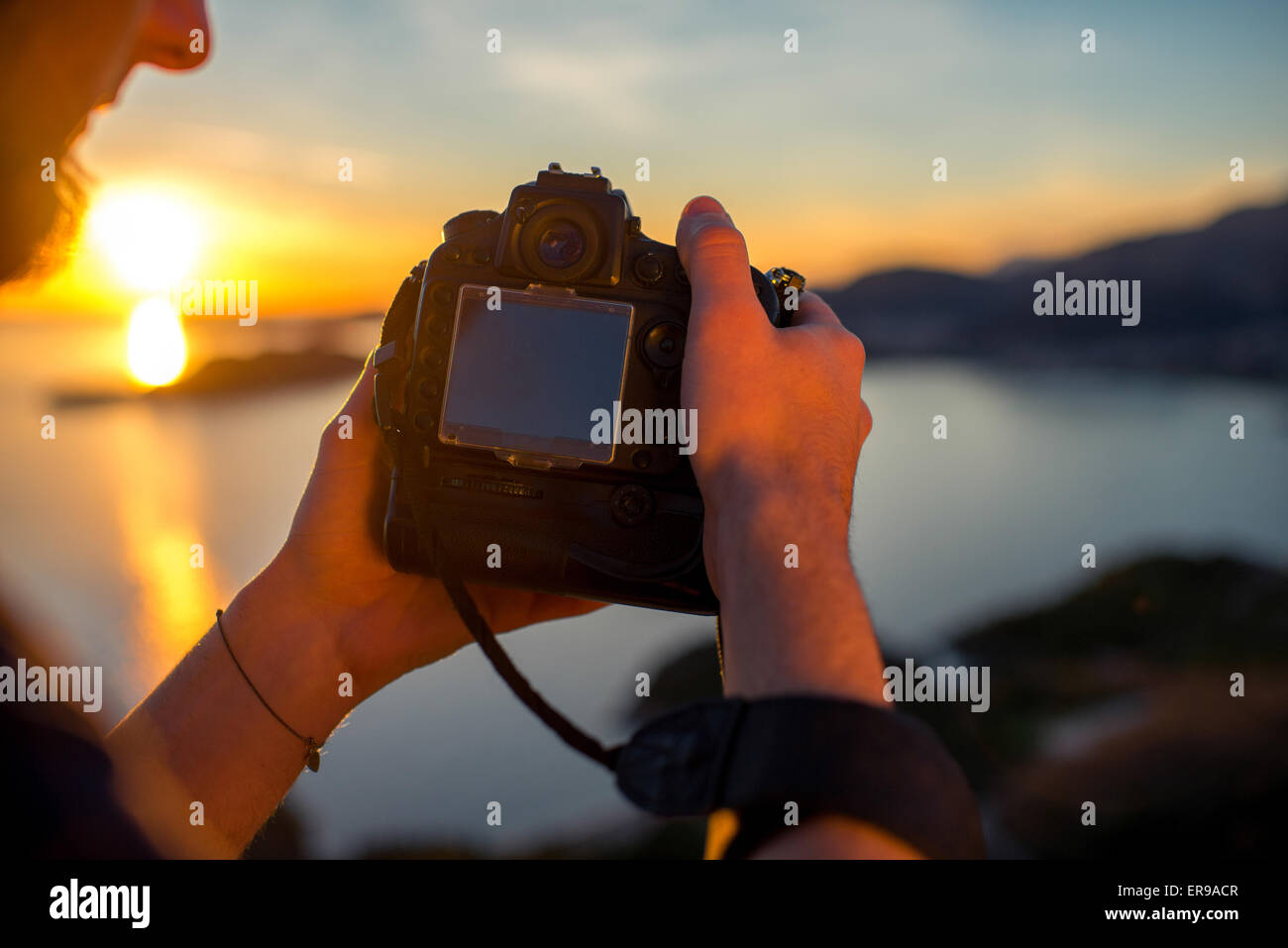 Man photographing sunset on the top of mountain Stock Photo - Alamy