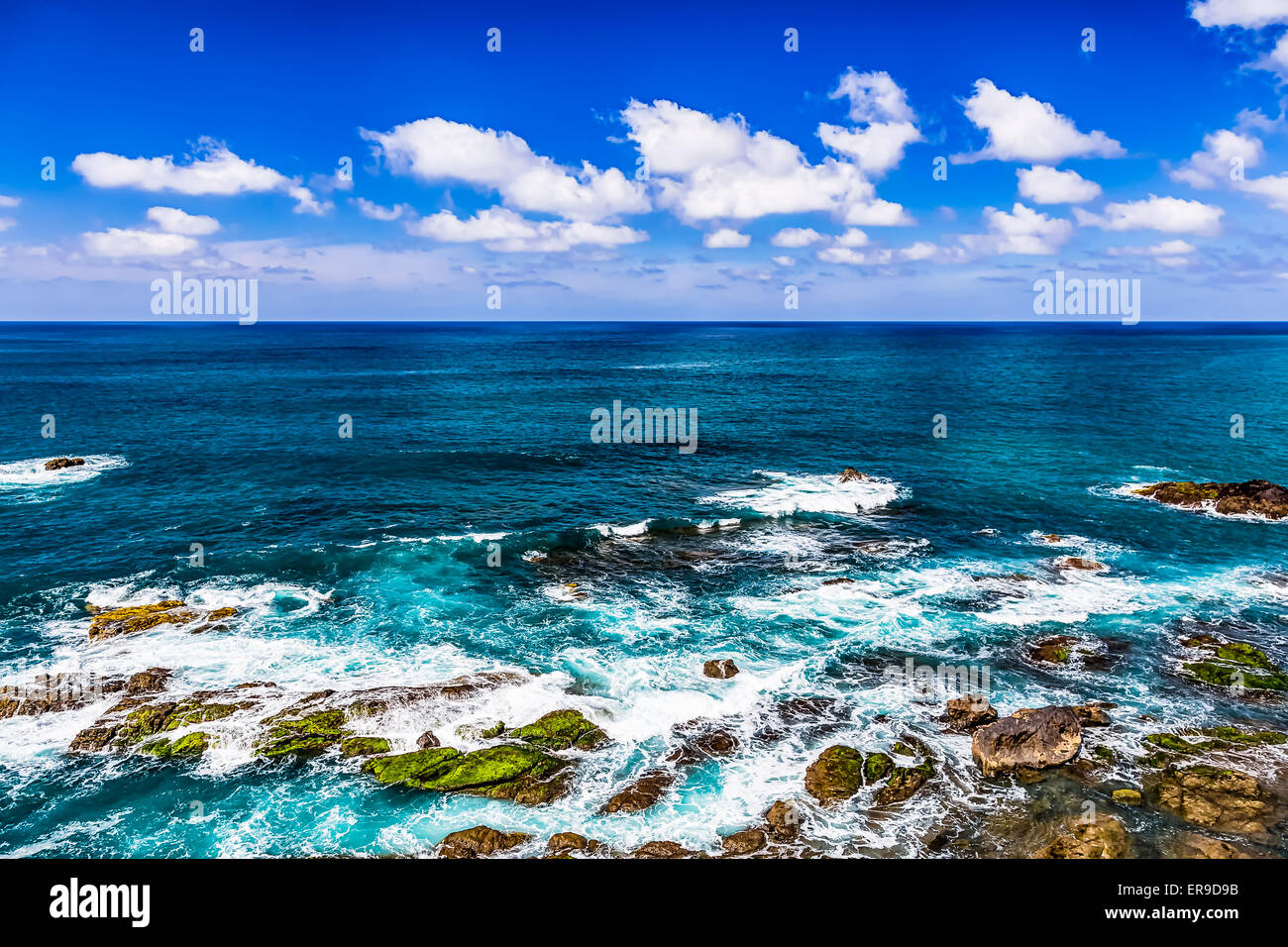Stone shore of Atlantic ocean and sky with clouds and skyline or ...
