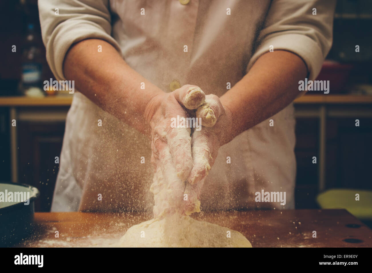Chef kneading homemade bread, clapping hands full of flour over dough ...