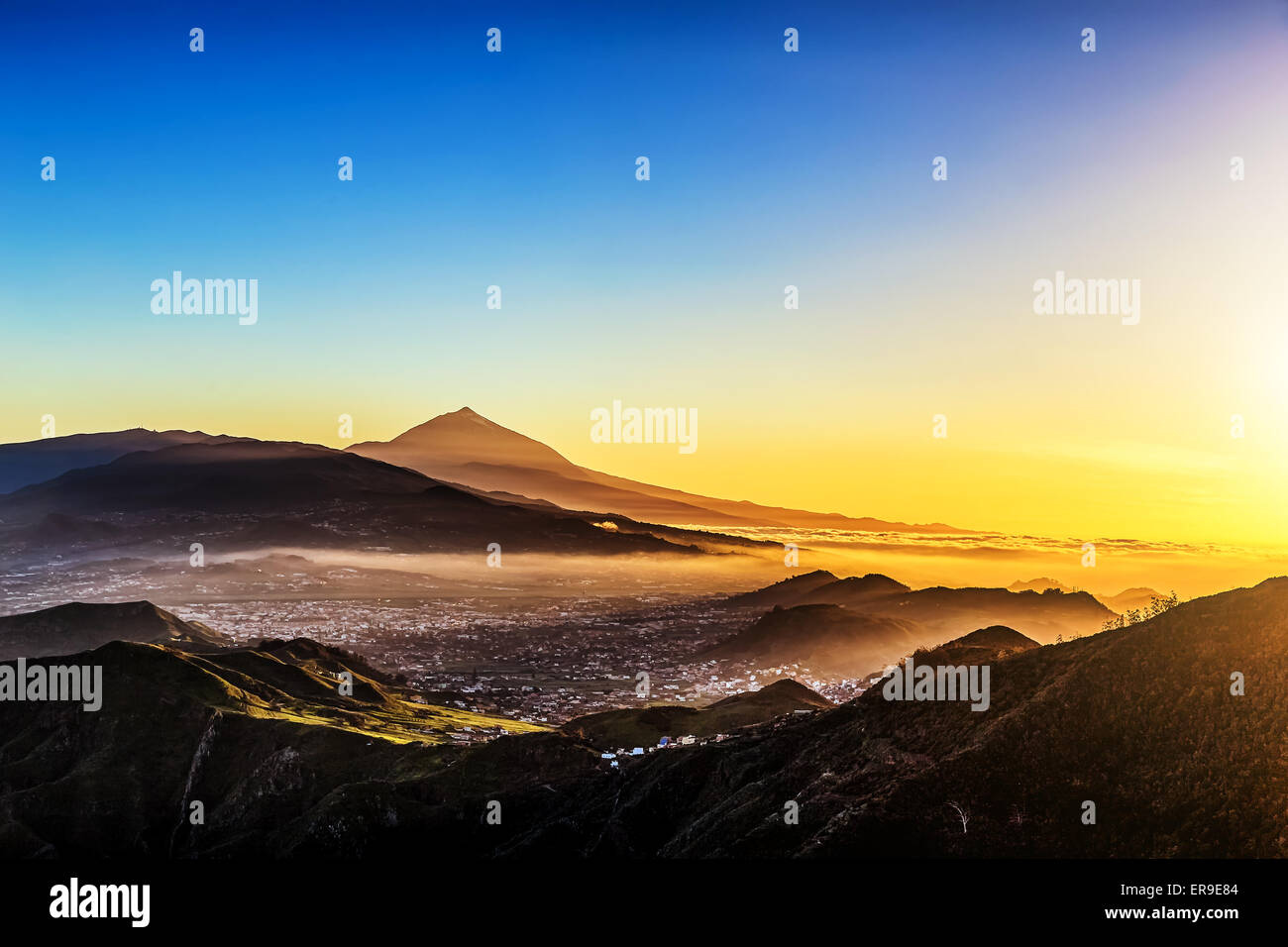 Sunset in mountains and blue sky with fog or haze and Teide volcano on ...