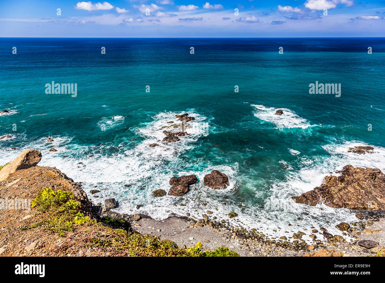 Stone coast or shore of ocean with waves and sky with clouds and ...