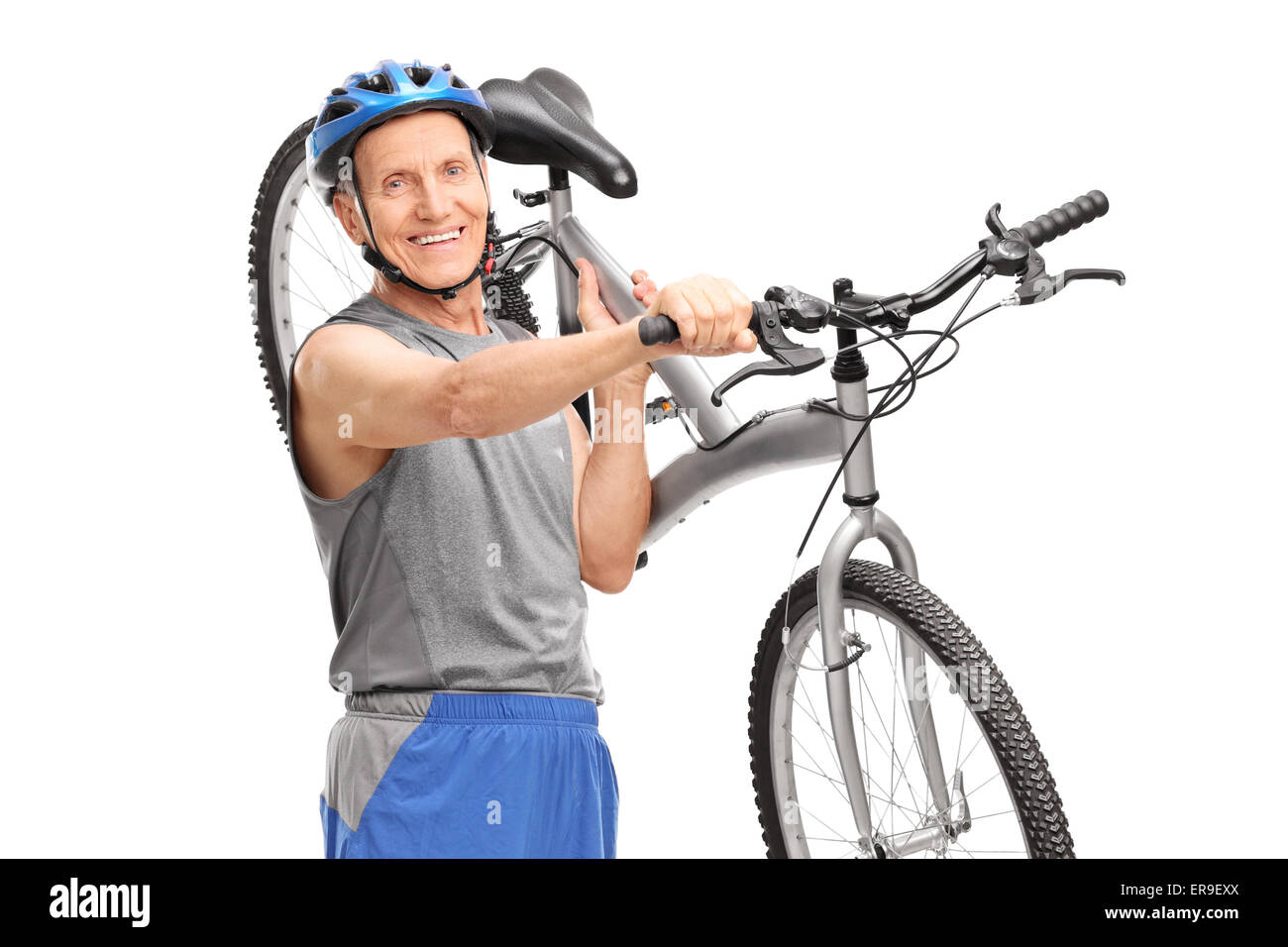 Active senior biker carrying his bicycle over his shoulder and looking ...