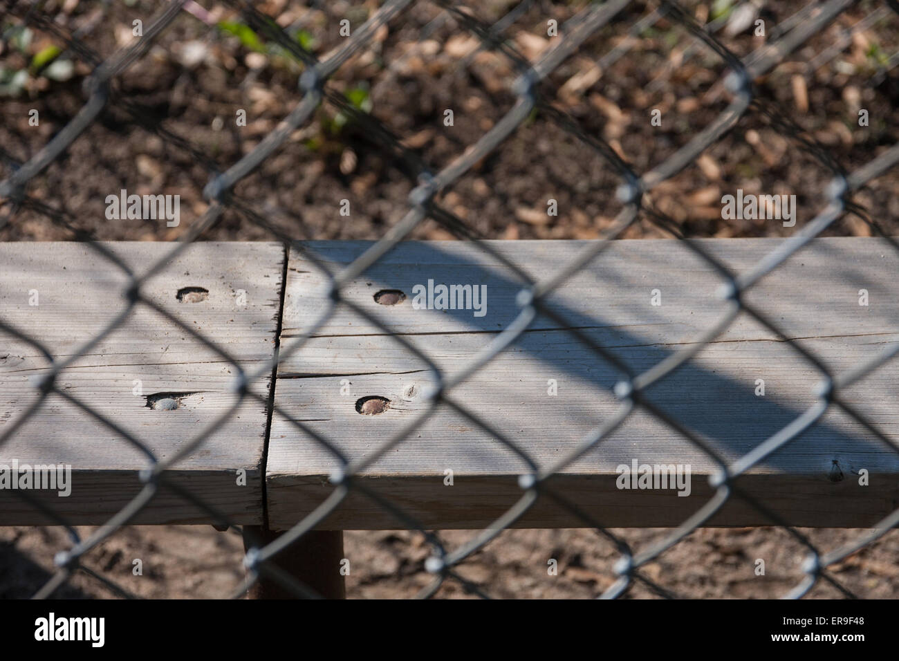 wooden bench and metal fence on sand Stock Photo - Alamy