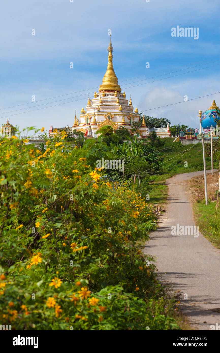The golden spire of a stupa rises to the sky at a buddhist temple in ...