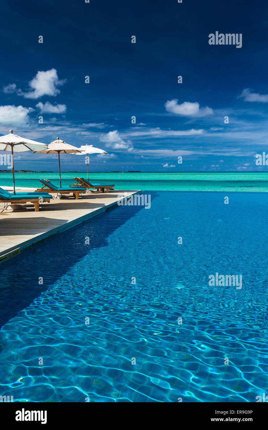 Infinity swimming pool on the beach of tropical island with white beach ...