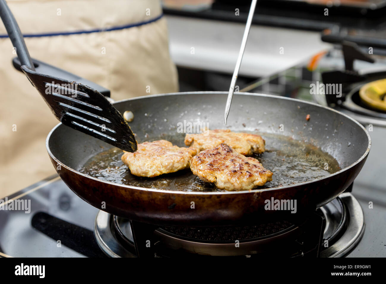 chef frying pork burger in the kitchen Stock Photo - Alamy