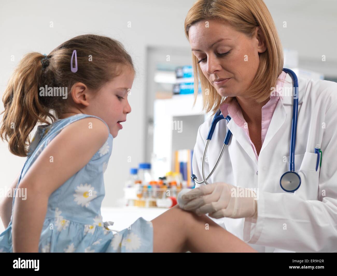 PROPERTY RELEASED. MODEL RELEASED. Doctor cleaning a knee wound in a ...