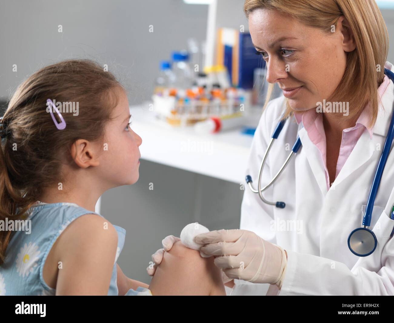 PROPERTY RELEASED. MODEL RELEASED. Doctor cleaning a knee wound in a ...