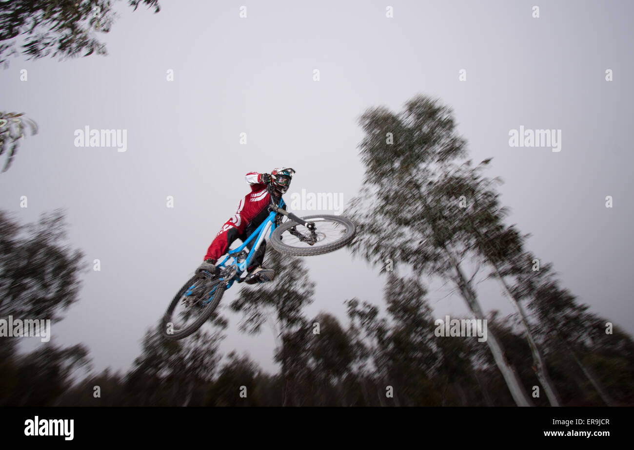 Mountain biker on a downhill course jumping through the air - motion ...