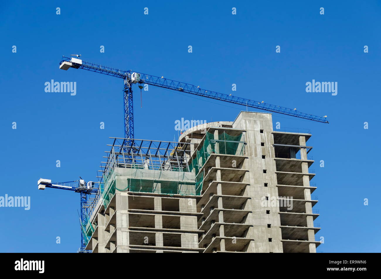Construction of many storeyed building and jib-crane Stock Photo - Alamy