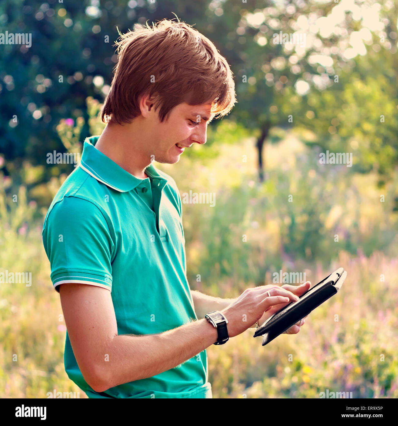 young guy with a tablet outdoors Stock Photo - Alamy