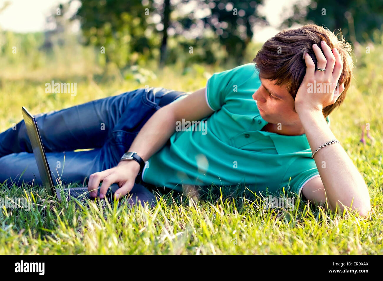 young guy looking at laptop outdoors Stock Photo - Alamy