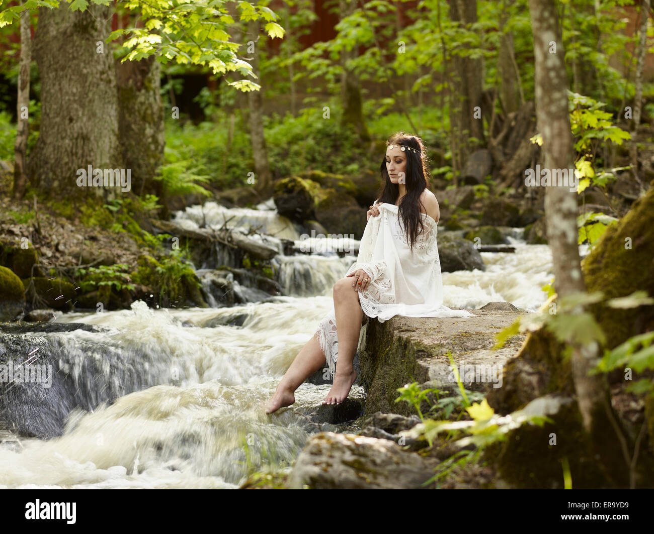 Beautiful brunette woman alone on a river, white dress Stock Photo - Alamy