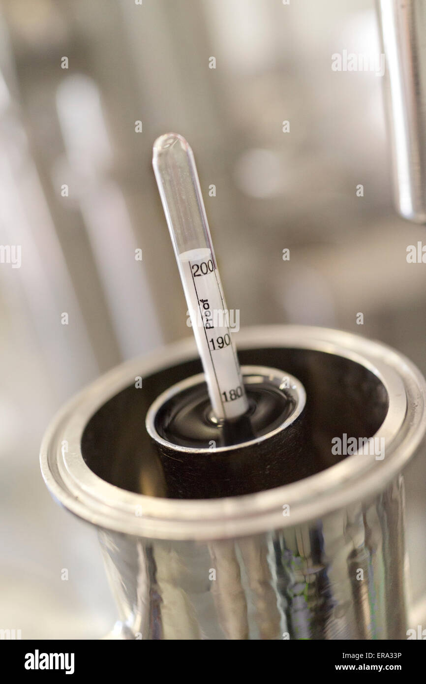 Alcoholmeter floating in alcohol at craft distillery. Vertical color ...