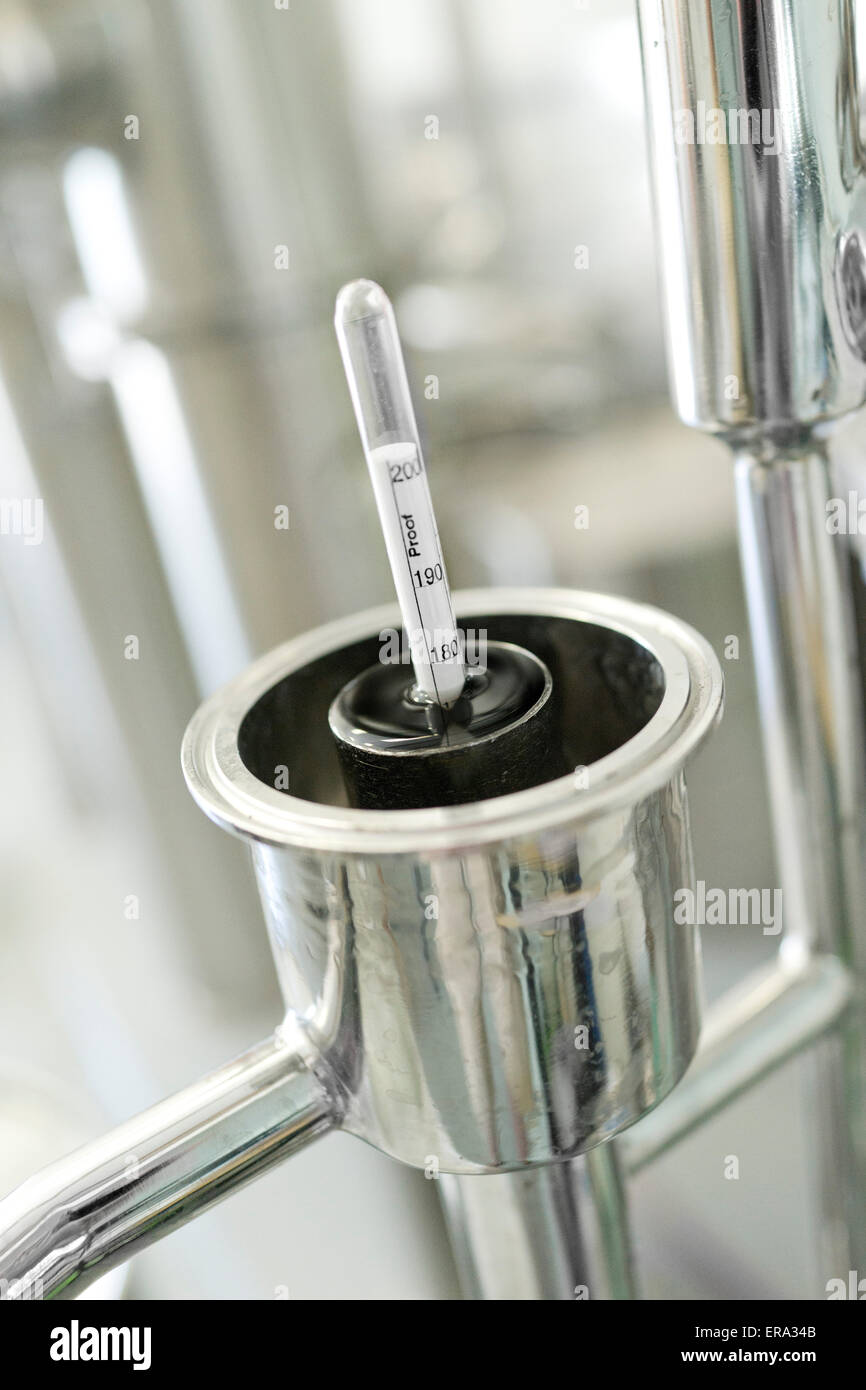 Alcoholmeter floating in alcohol at craft distillery. Vertical color ...