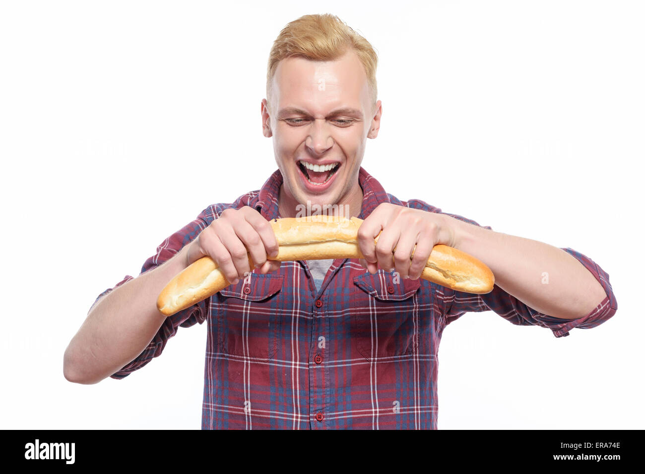 Smiling man breaking long loaf Stock Photo - Alamy